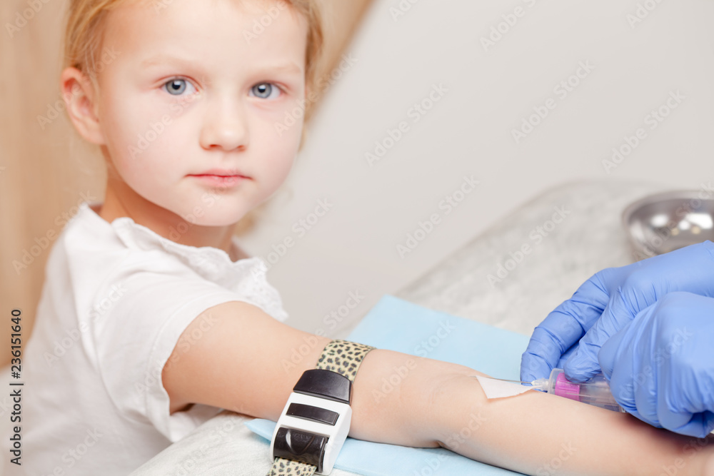 Nurse takes a blood sample from little girls arm - pediatric ...