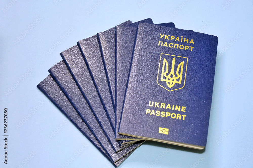 Ukraine passports with golden trident emblem and letters on blue ...