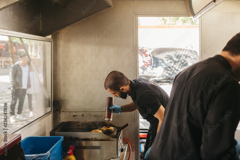 Chef cooking burgers on the grill in a food truck Stock Photo | Adobe Stock