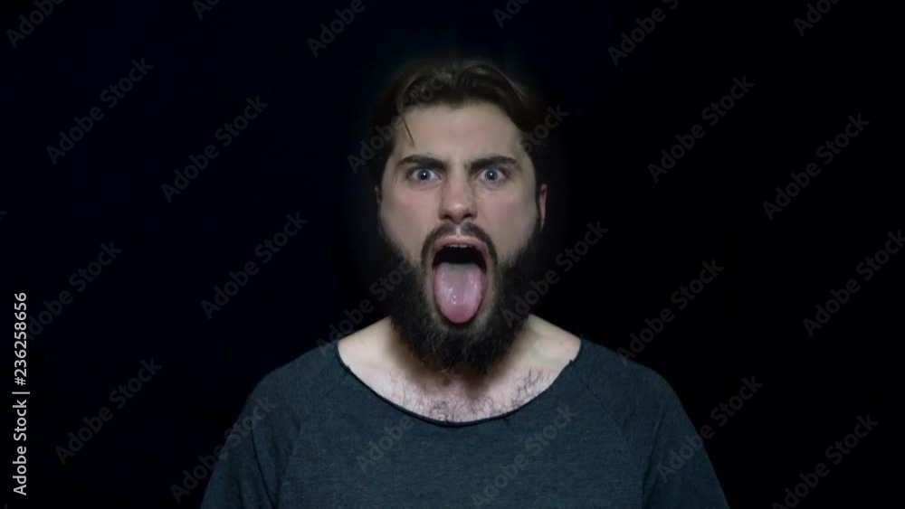 Video Stock Young man with beard and tongue sticking out in rage. Angry ...
