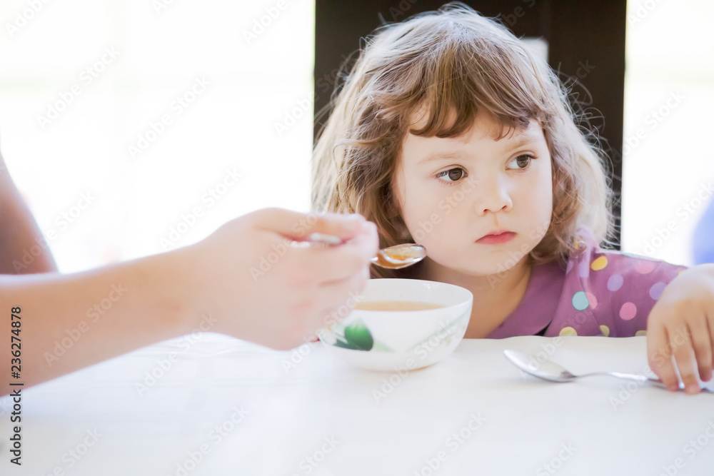 Cute little girl doesn't want to eat. Kid refusing food. Sad child ...