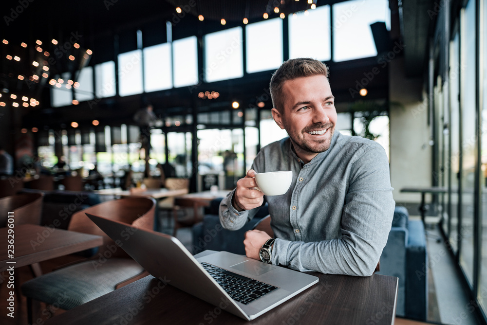 Foto de Handsome man drinking coffee in modern cafe. do Stock | Adobe Stock