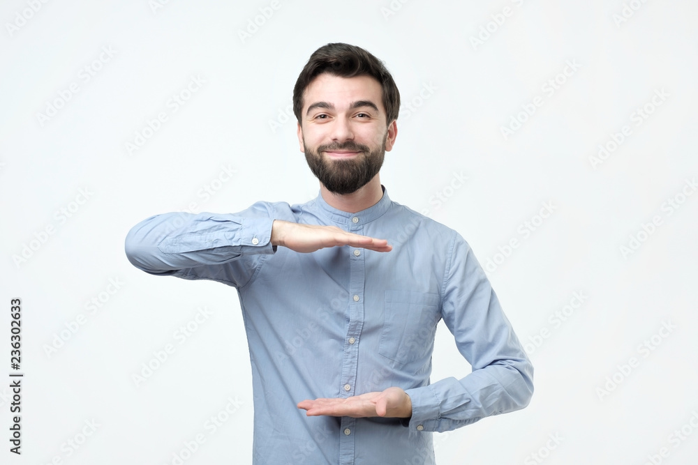 Hispanic man with beard holding two hands in front of him and shows the ...