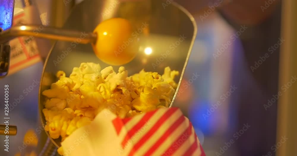 Popcorn is poured into a bag for guests to enjoy. Captured in a slow ...