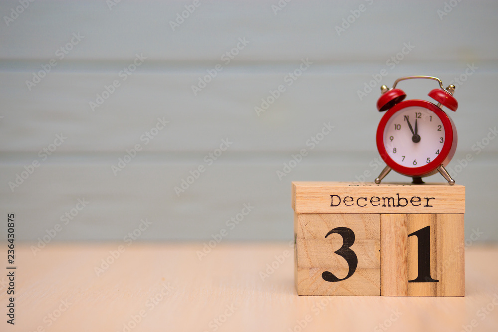 December 31st set on wooden calendar and red alarm clock with blue ...