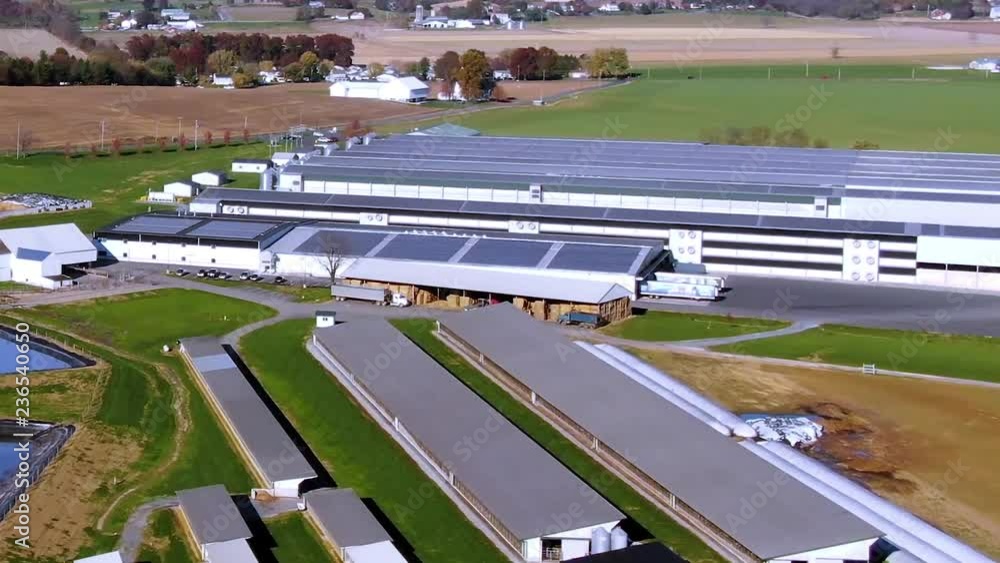 Huge farm in rural landscape, livestock barn facilities in front and ...