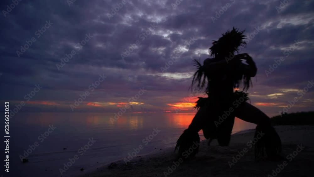 Young graceful male dancing at sunset on ocean beach Tahitian hula ...