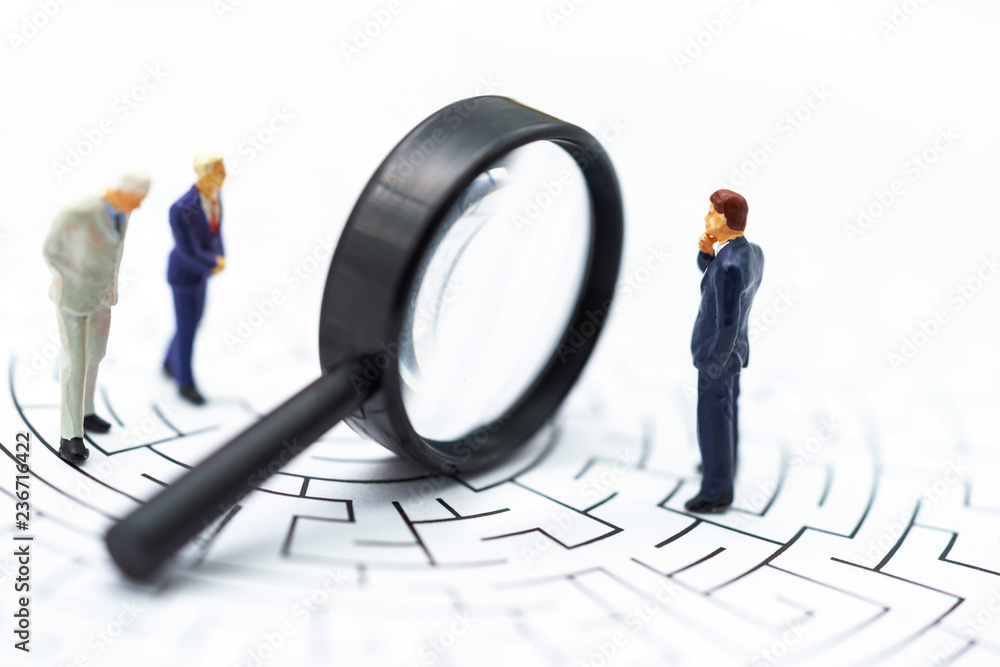 .Miniature people: Businessman use magnifying glass to find the route ...
