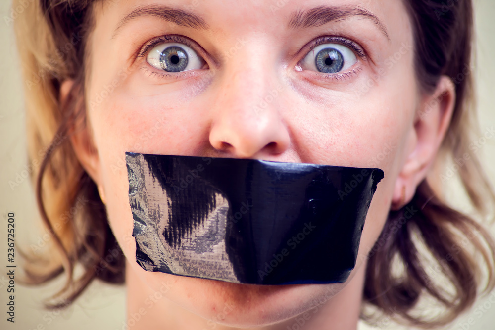 Upset girl with self-adhesive tape over her mouth. Kidnapping concept ...