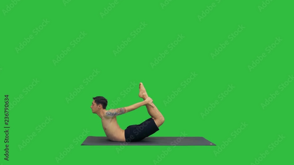 Sporty muscular young yogi man doing backbend exercise, dhanurasana ...