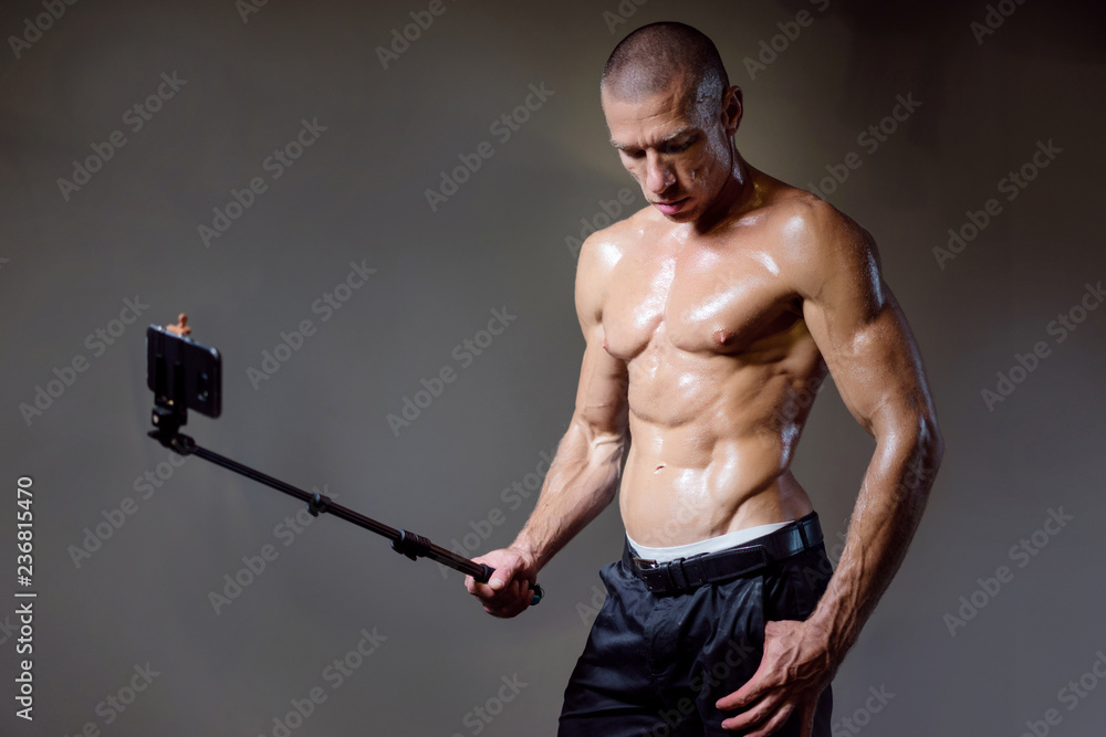 The athlete takes pictures of himself. Man with muscles. Inflated man ...
