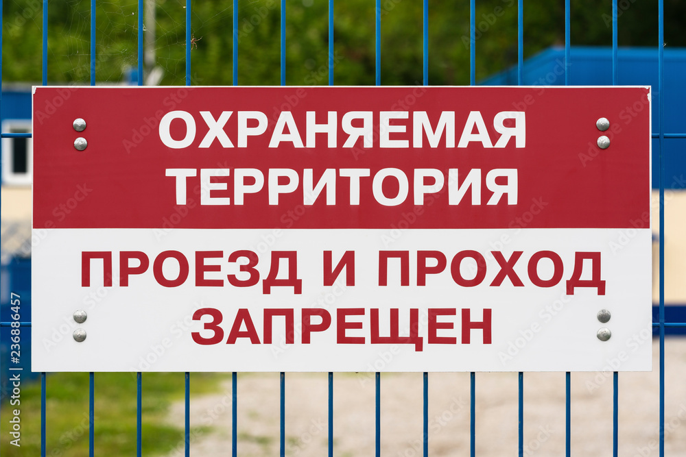 Red and white prohibition sign on green lattice metal fence, text in ...