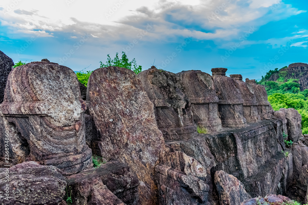 big circular rock shaped vertical located close top front & side view ...