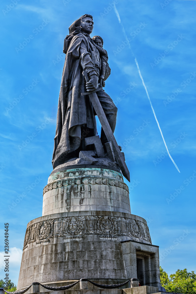 Statue of a Soviet soldier with a sword holding a German girl at ...