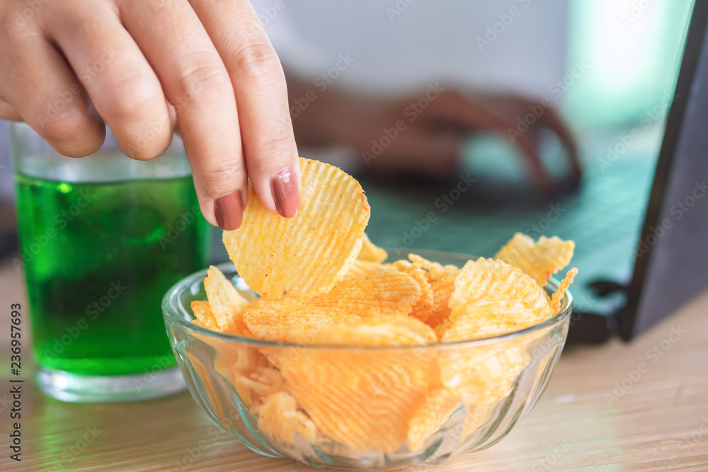 business woman hand eating fast food potato chips with soda glass while ...