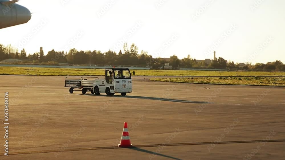 Close up outside of an airfield track with a car cloudly sky plane ...