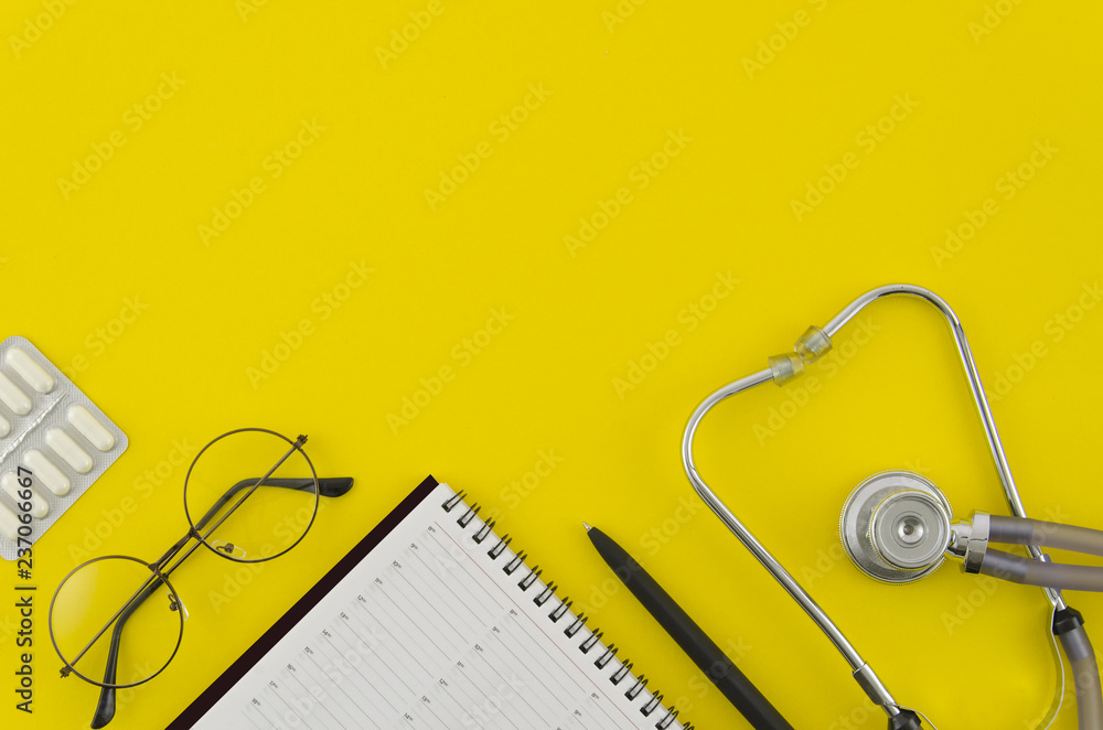 Top view medical stethoscope and white calendar on yellow background ...