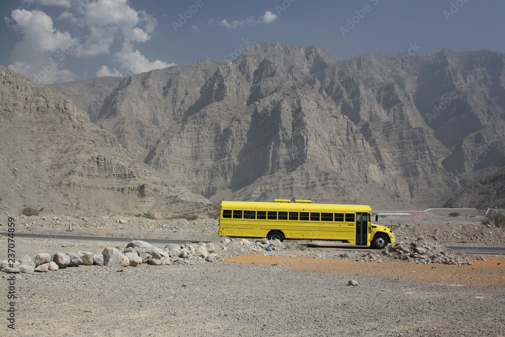 american yellow school bus in desert mountains in united arab emirates ...