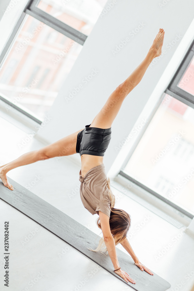 young talented girl trying to do standing splits. side view full length ...