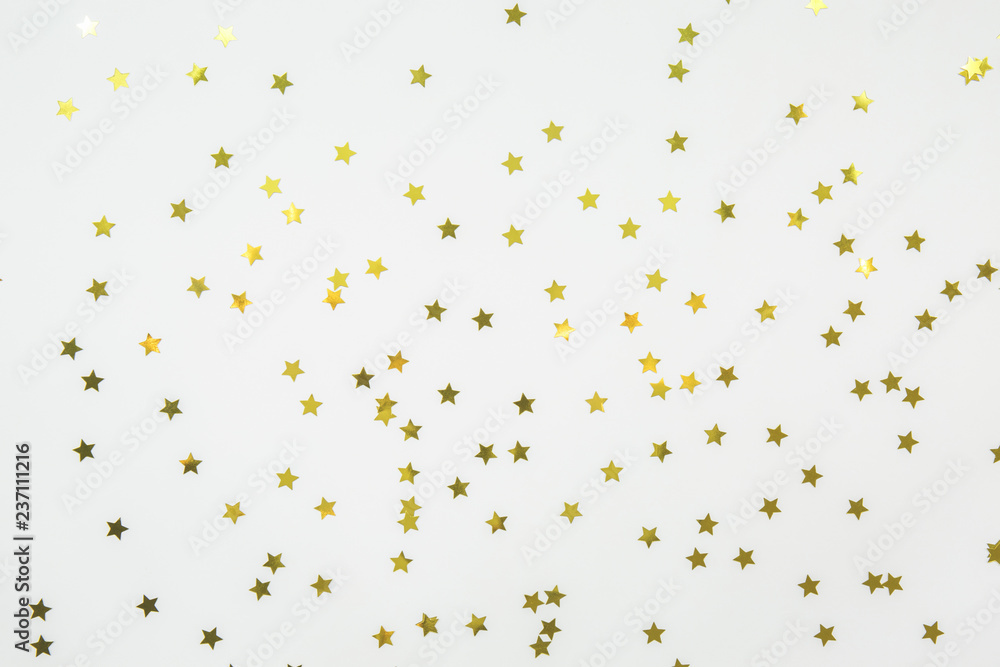 Golden star sprinkles on white. Festive holiday background. Celebration ...