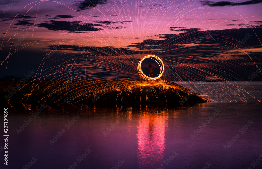 The beautiful fire dancer swing fire dancing show on the beach with ...