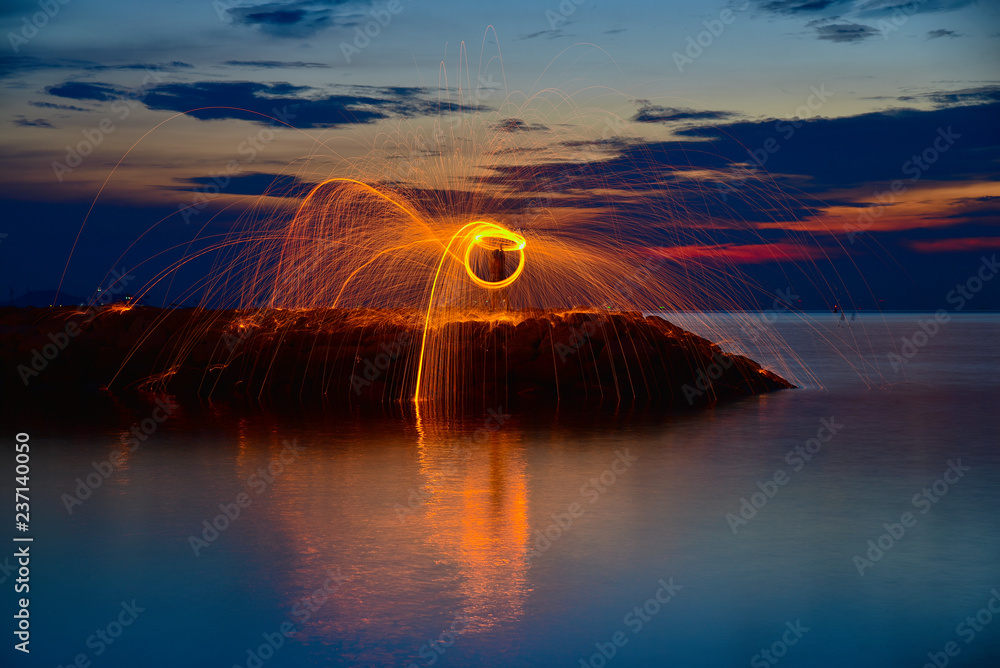 The beautiful fire dancer swing fire dancing show on the beach with ...