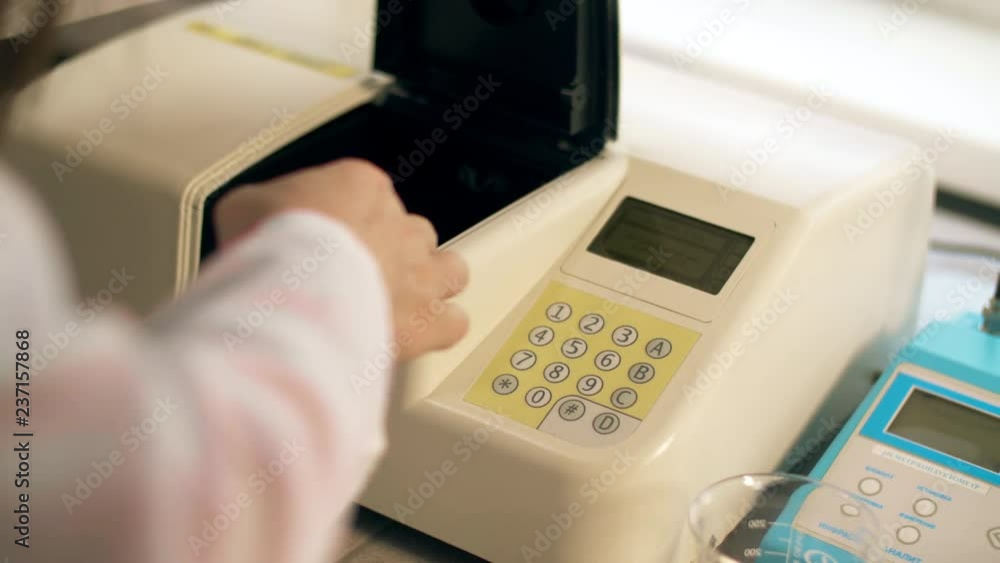 Scientist puts test tube into medical spectro in laboratory or hospital ...