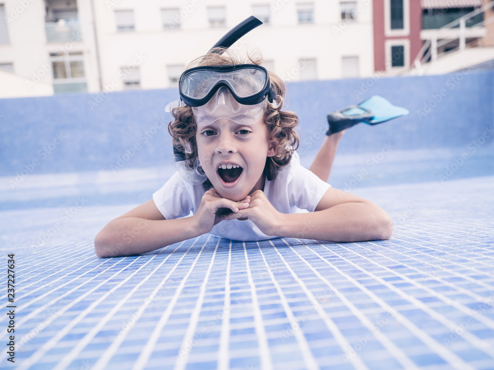 Boy in diving equipment lying on floor of pool Stock Photo | Adobe Stock