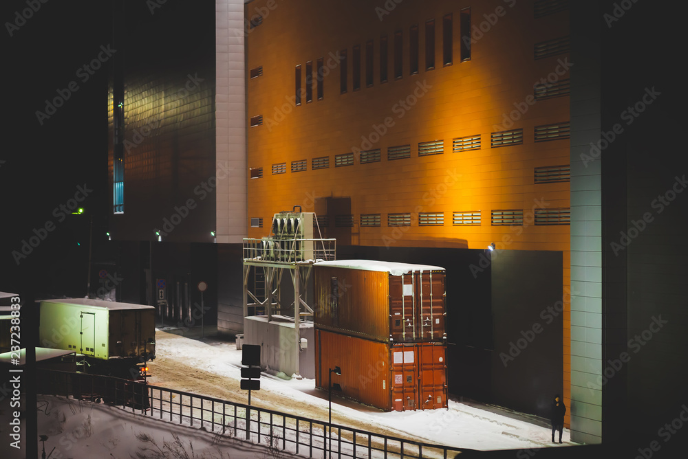 Truck with trailer parked near container in industrial area in winter ...