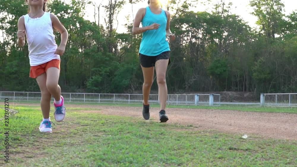 running sporty mother and daughter. woman and child jogging outdoor ...