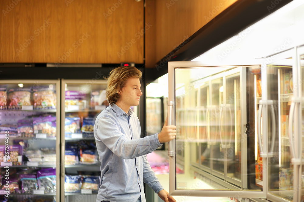 Man choosing frozen food from a supermarket freezer Stock Photo | Adobe ...