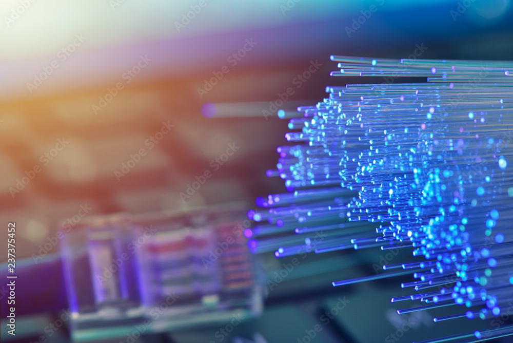 Fiber optics in blue, close up with ethernet and keyboard background ...
