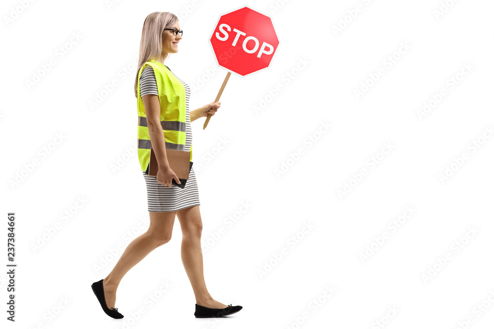 Young woman holding a stop sign and wearing a safety vest walking Stock ...