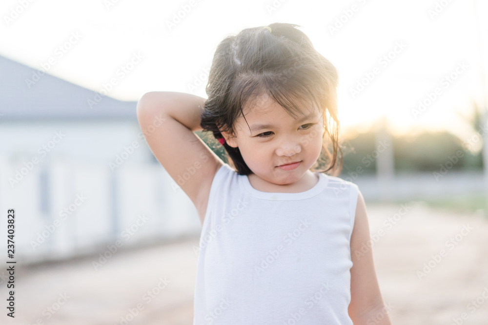 Little asian girl scratching an itch with hand outdoor.Kid's hand ...