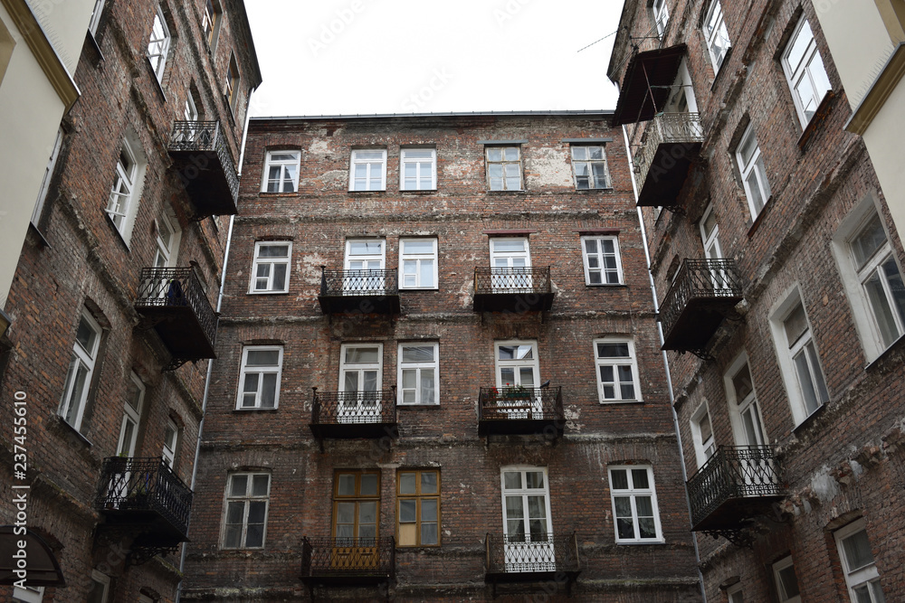 Vintage red brick slum house with balconies and damaged walls in Warsaw ...
