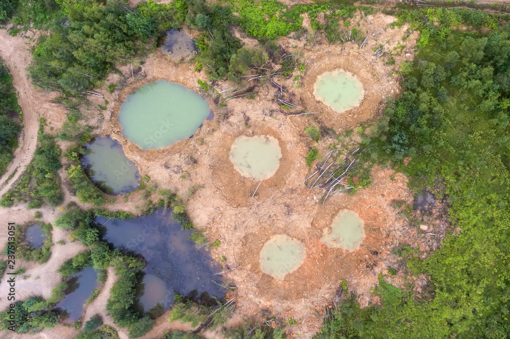 Holes on ground from powerful explosions. Bomb craters in the forest ...