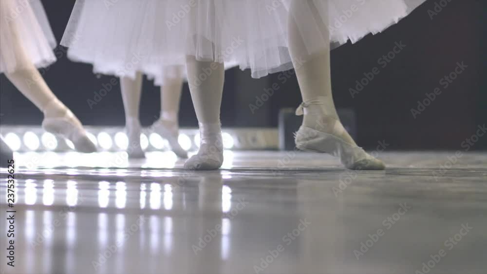 Ballet. Close-up of a girl's legs in white ballet shoes during ballet ...