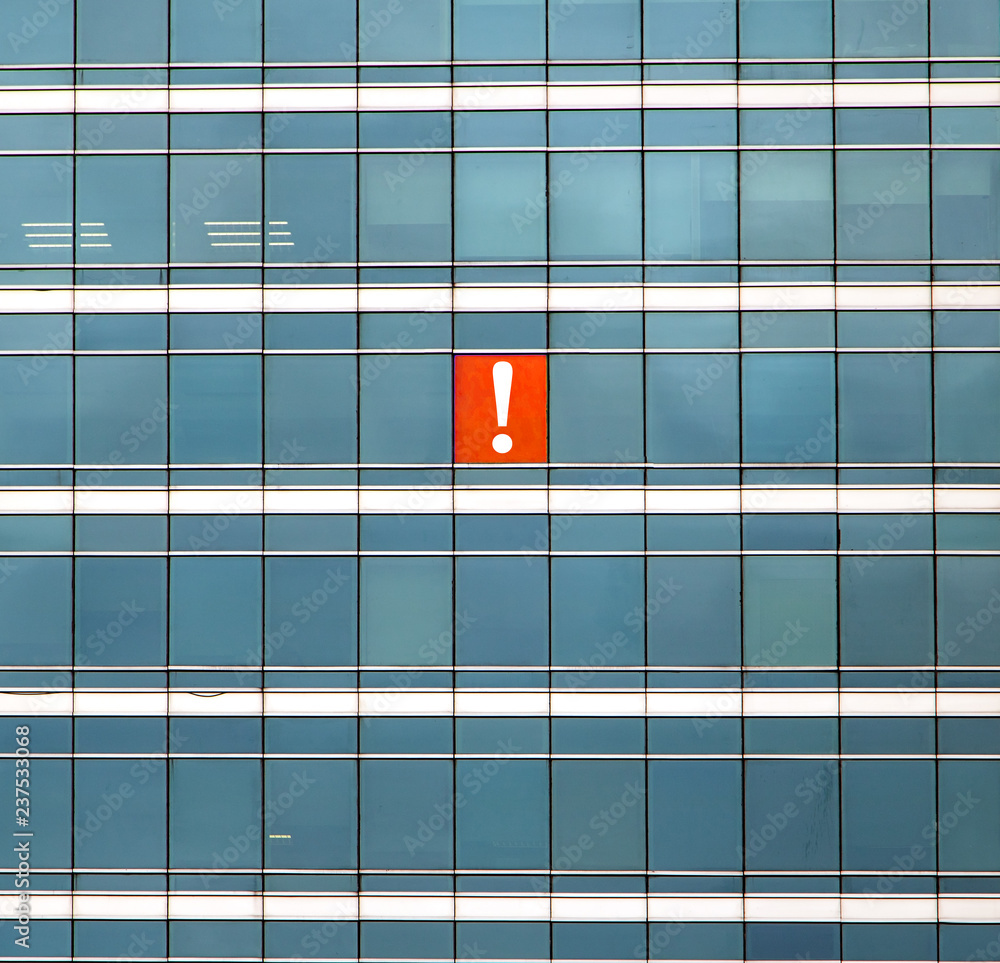 The symbol of the exclamation mark on the building's window. The glass ...
