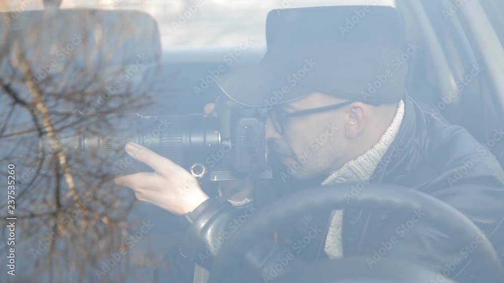 A private detective or a spy conducts surveillance of the object of ...