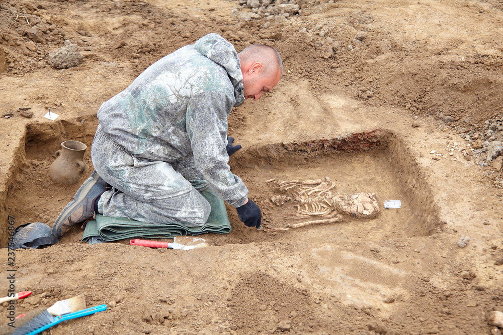 Archaeological excavation. The archaeologist in a digger process ...