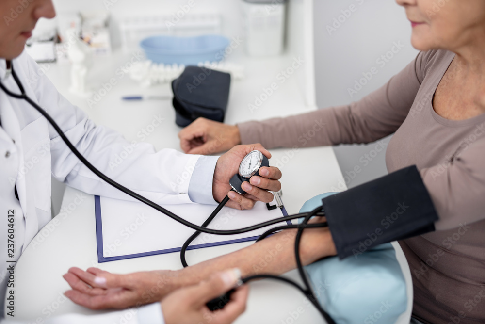 Concentrated general practitioner carefully measuring the blood ...