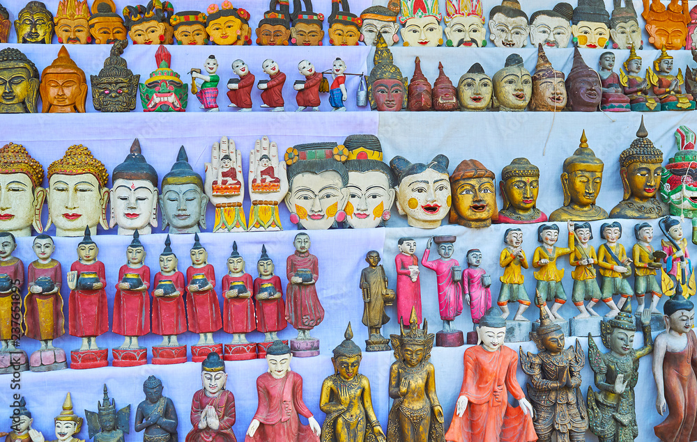 The carved wooden Buddhist souvenirs in market stall: images of Buddha ...