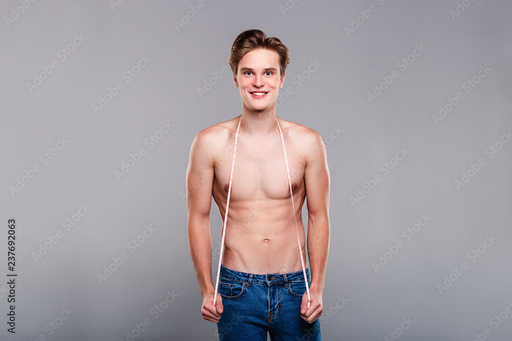 In perfect shape. Handsome shirtless young man in jeans holding ...