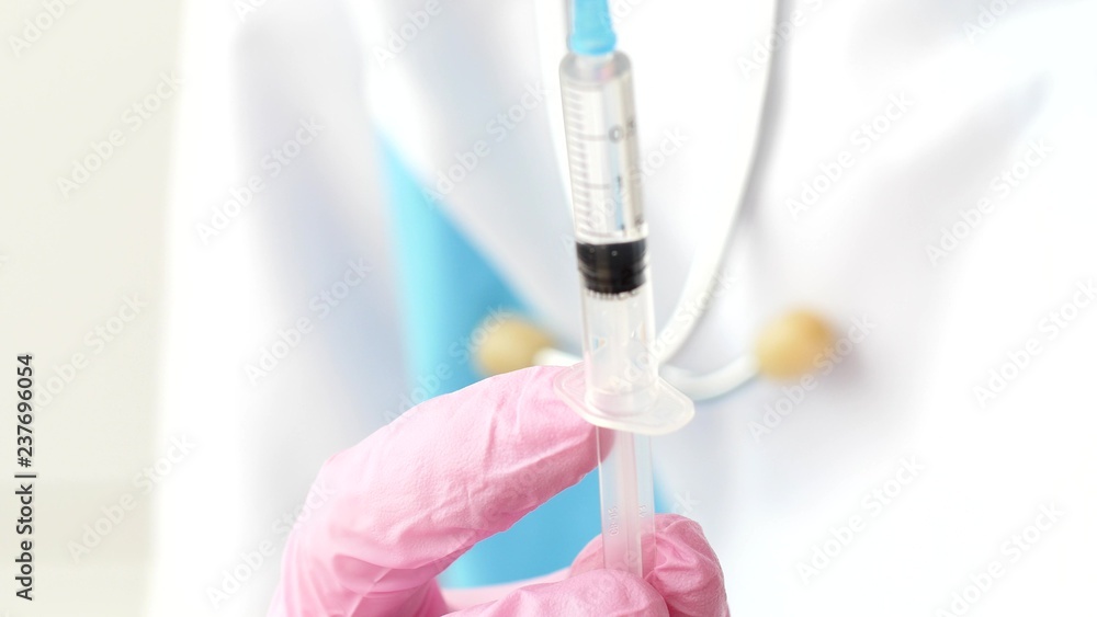 Medical doctor picking up medication into a single use syringe and ...