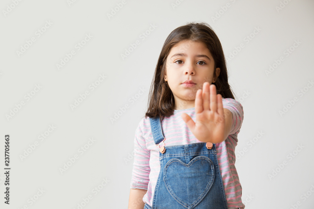 Little serious Hispanic girl making stop gesture. Adorable kid ...