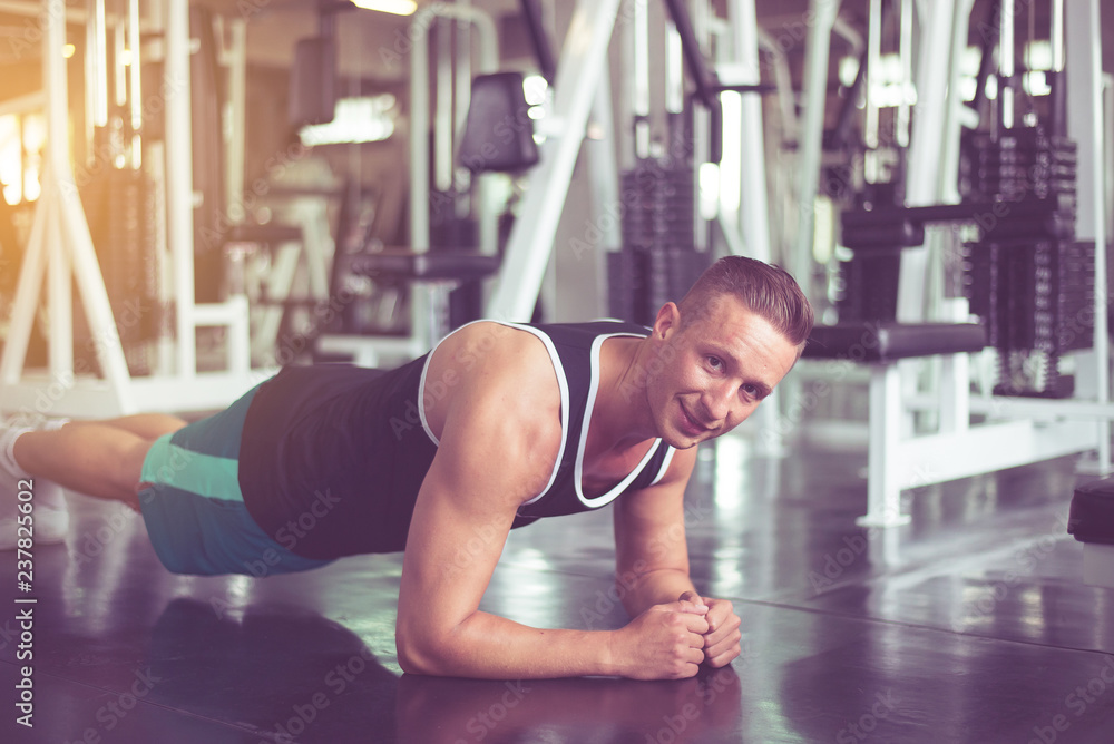 Sport man doing plank exercises training core full lenght in gym ...