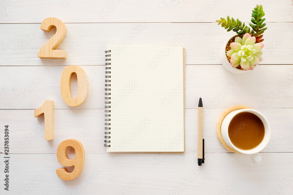 2019 wood letters, blank notebook paper and coffee on white table ...
