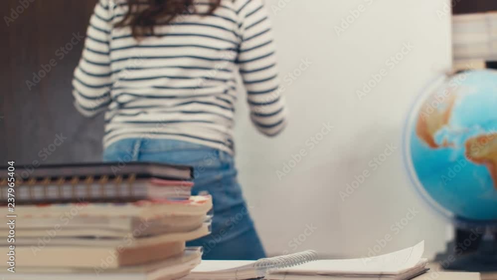 Close up of cute caucasian girl with glasses writing homework at home ...