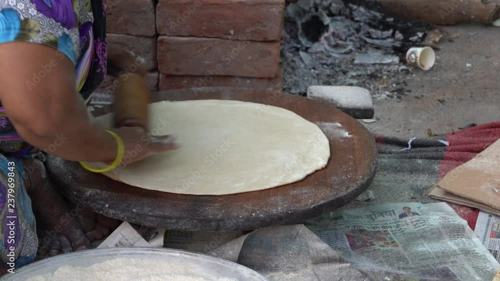 Indian woman cooking traditional indian bread, big chapati cooking on ...