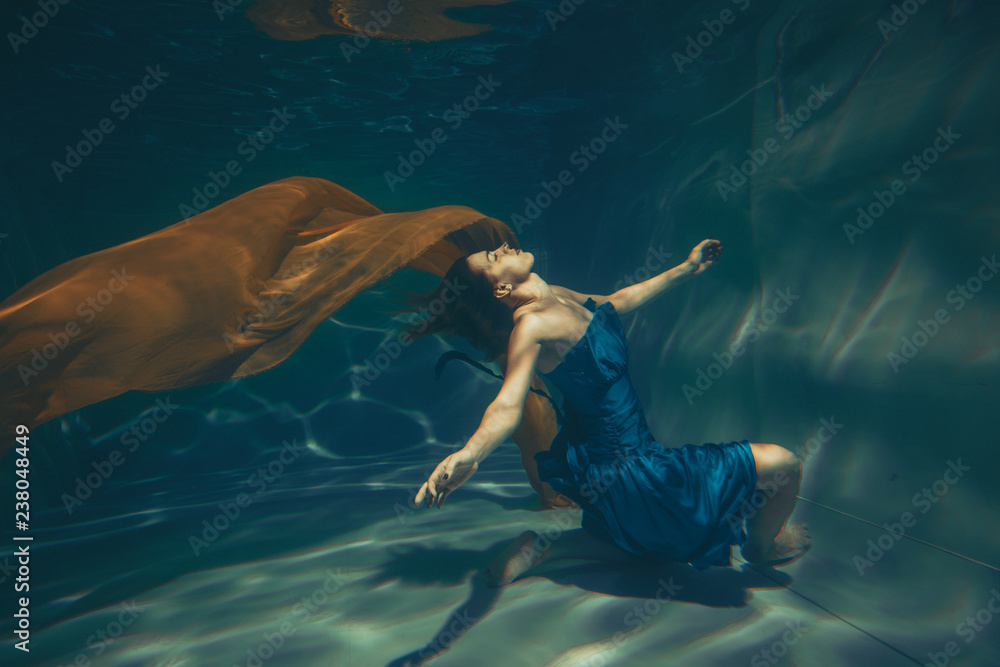 Cute Sporty Female Swims Underwater As A Free Diver In A Blue Evening